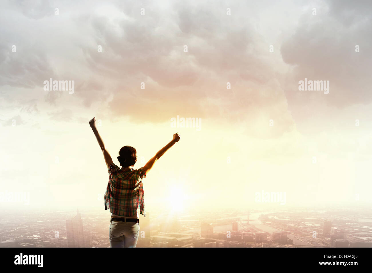 Back view of cheerful woman with hands up facing sunrise Stock Photo ...