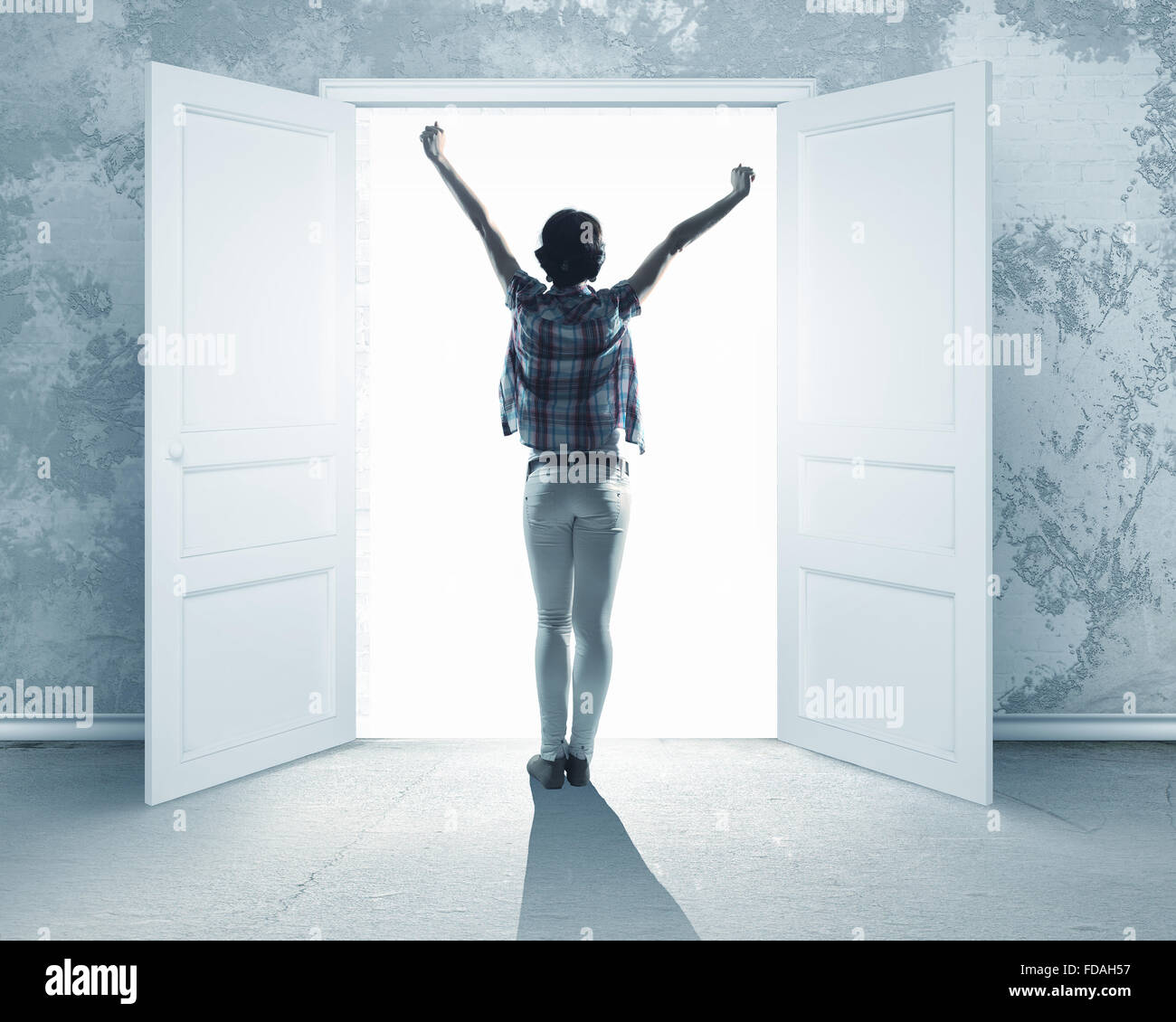 Rear view of woman with hands up entering opened door Stock Photo - Alamy