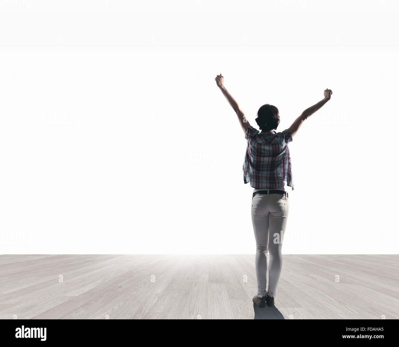Rear view of woman with hands up facing success Stock Photo - Alamy