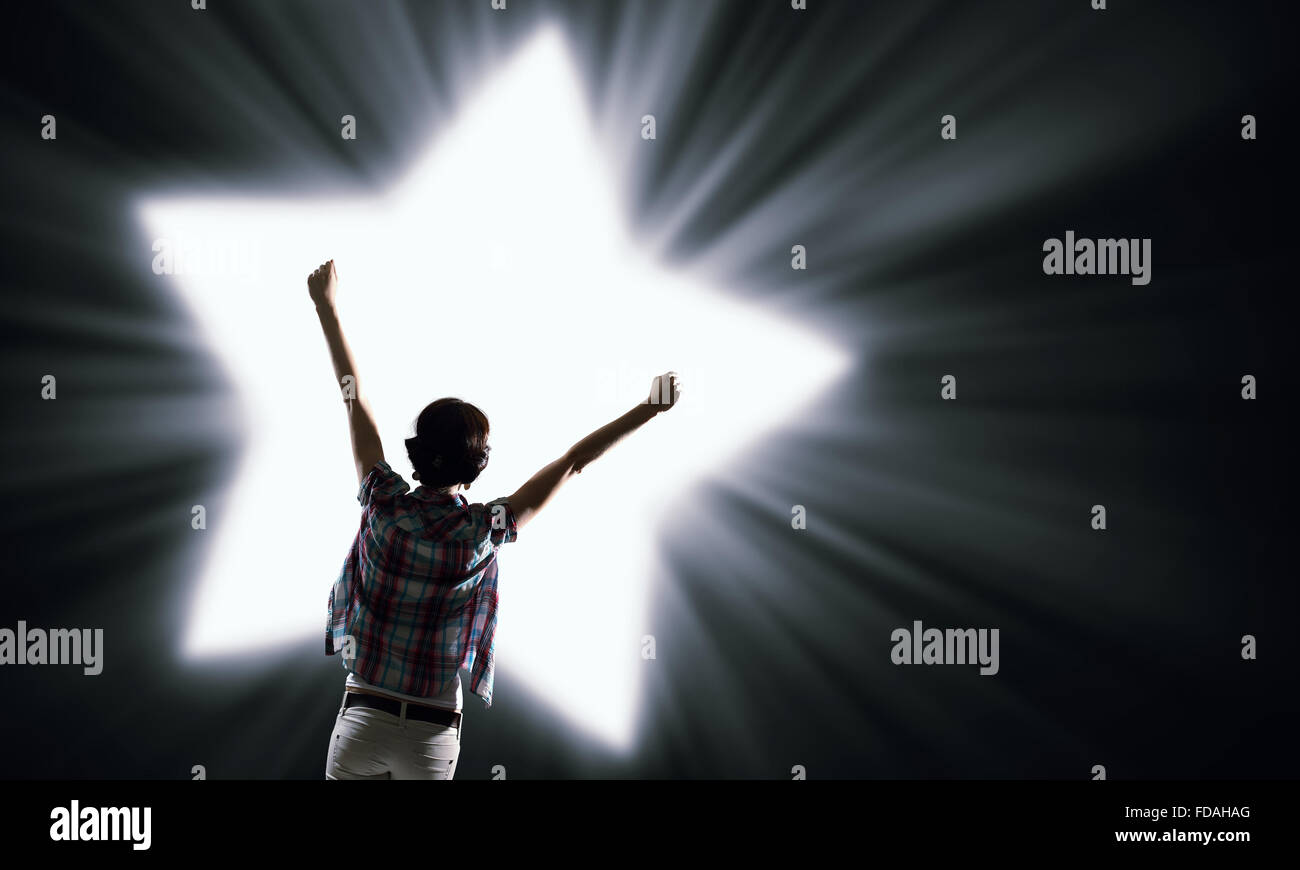 Rear view of woman with hands up facing success Stock Photo - Alamy
