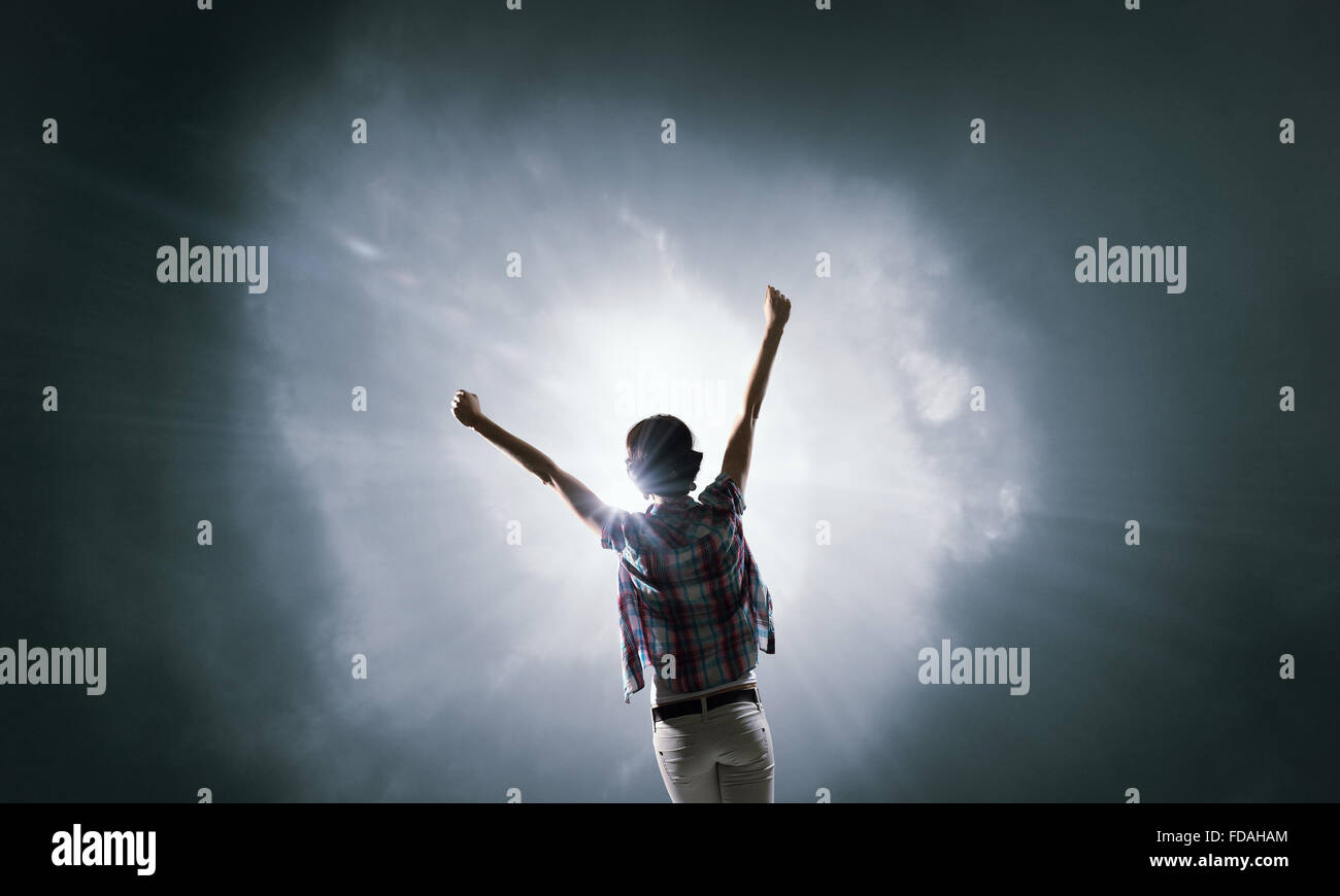 Rear view of woman with hands up facing success Stock Photo - Alamy