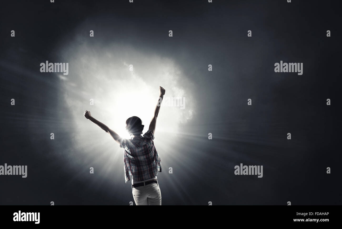 Rear view of woman with hands up facing success Stock Photo - Alamy
