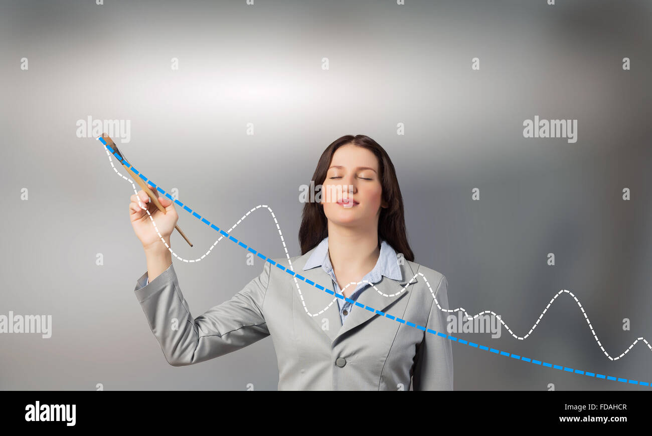 Young businesswoman drawing increasing graph with paint brush Stock ...