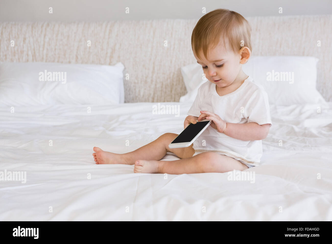 Cute baby using smartphone Stock Photo - Alamy