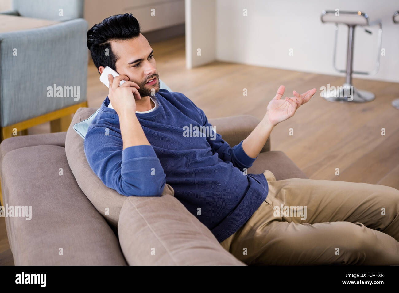 Handsome man calling on the couch Stock Photo - Alamy