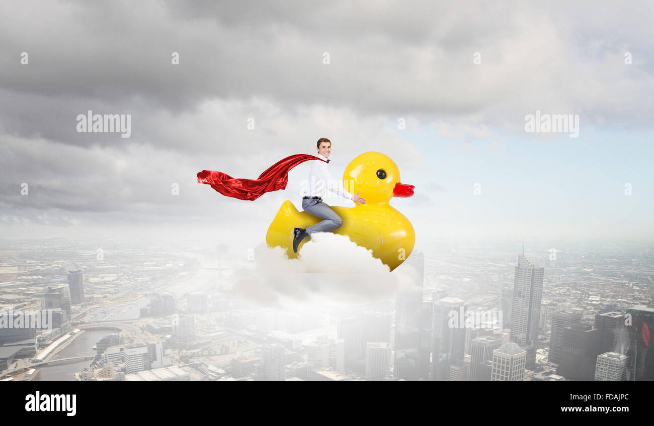 Young happy businessman riding yellow rubber duck Stock Photo - Alamy
