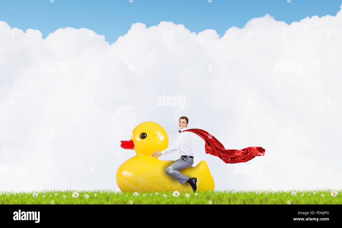 Young happy businessman riding yellow rubber duck Stock Photo - Alamy