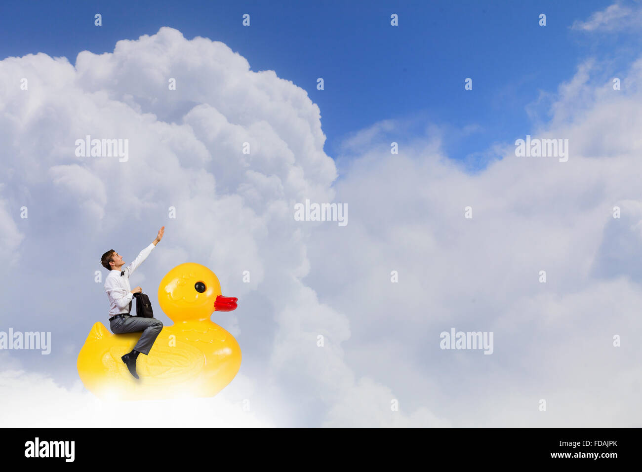 Young happy businessman riding yellow rubber duck Stock Photo - Alamy
