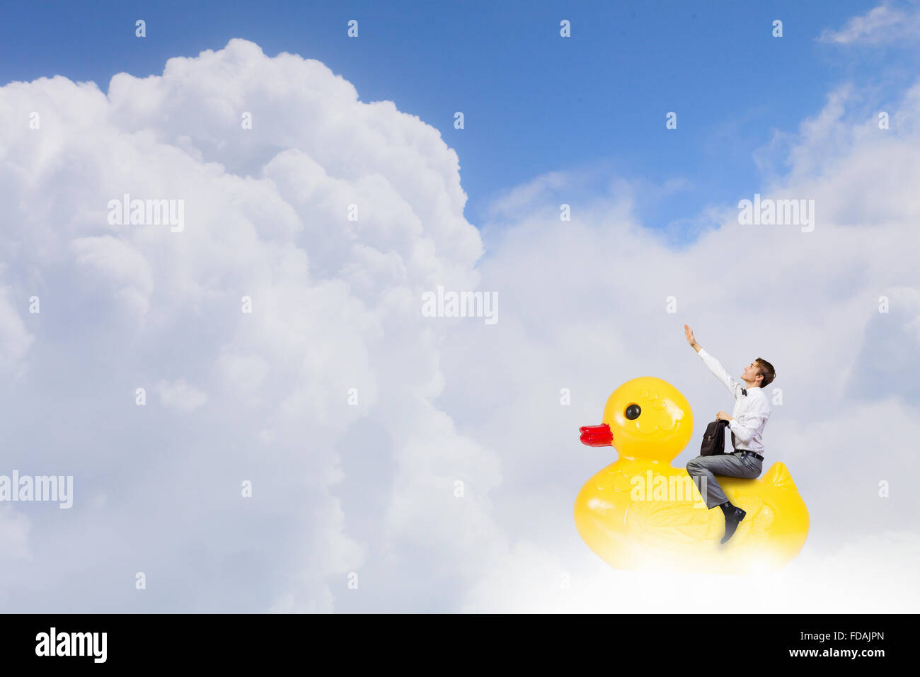 Young happy businessman riding yellow rubber duck Stock Photo - Alamy