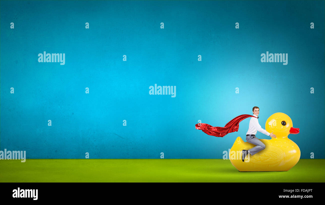 Young happy businessman riding yellow rubber duck Stock Photo - Alamy