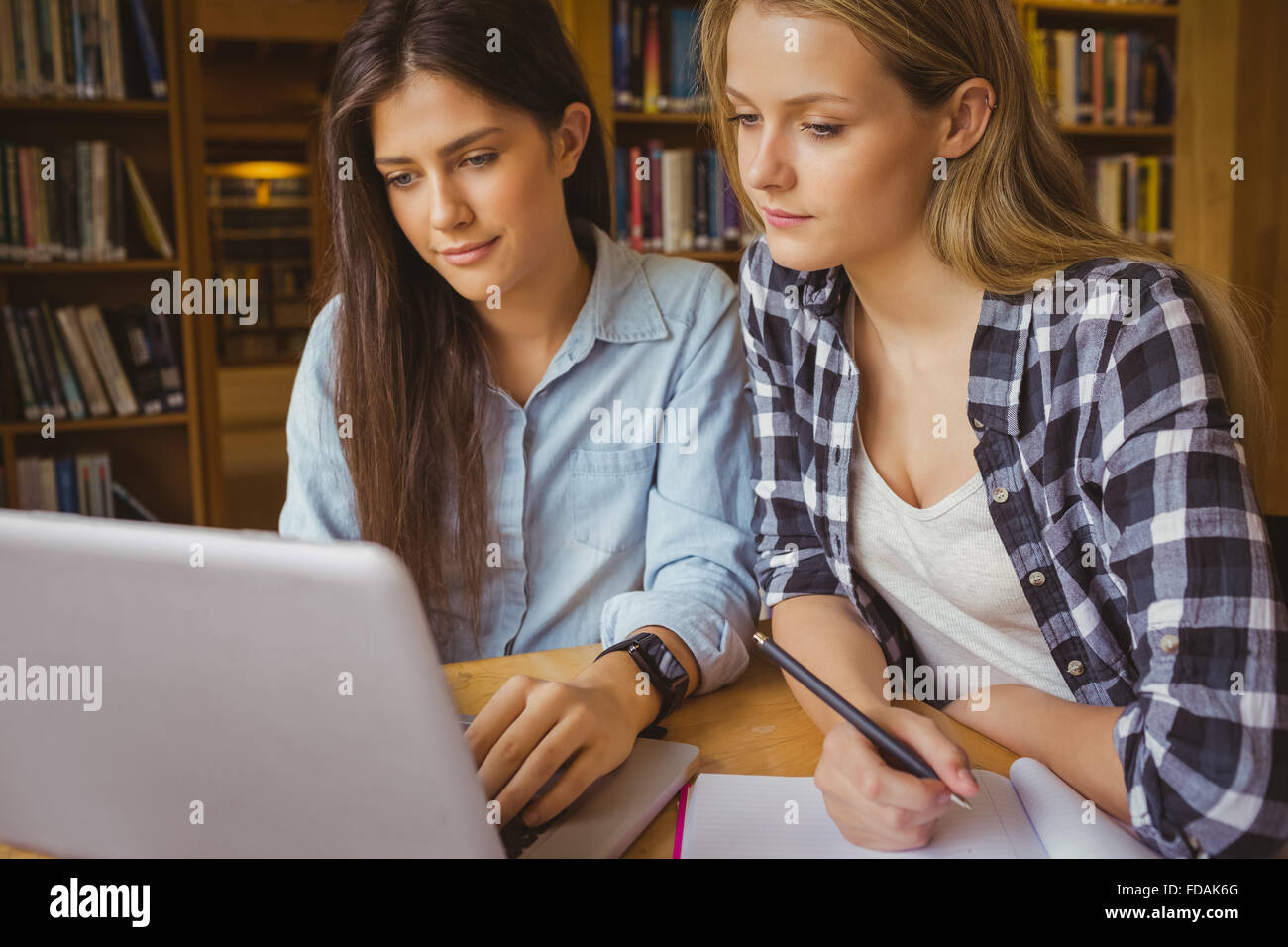 Smiling students using laptop Stock Photo - Alamy