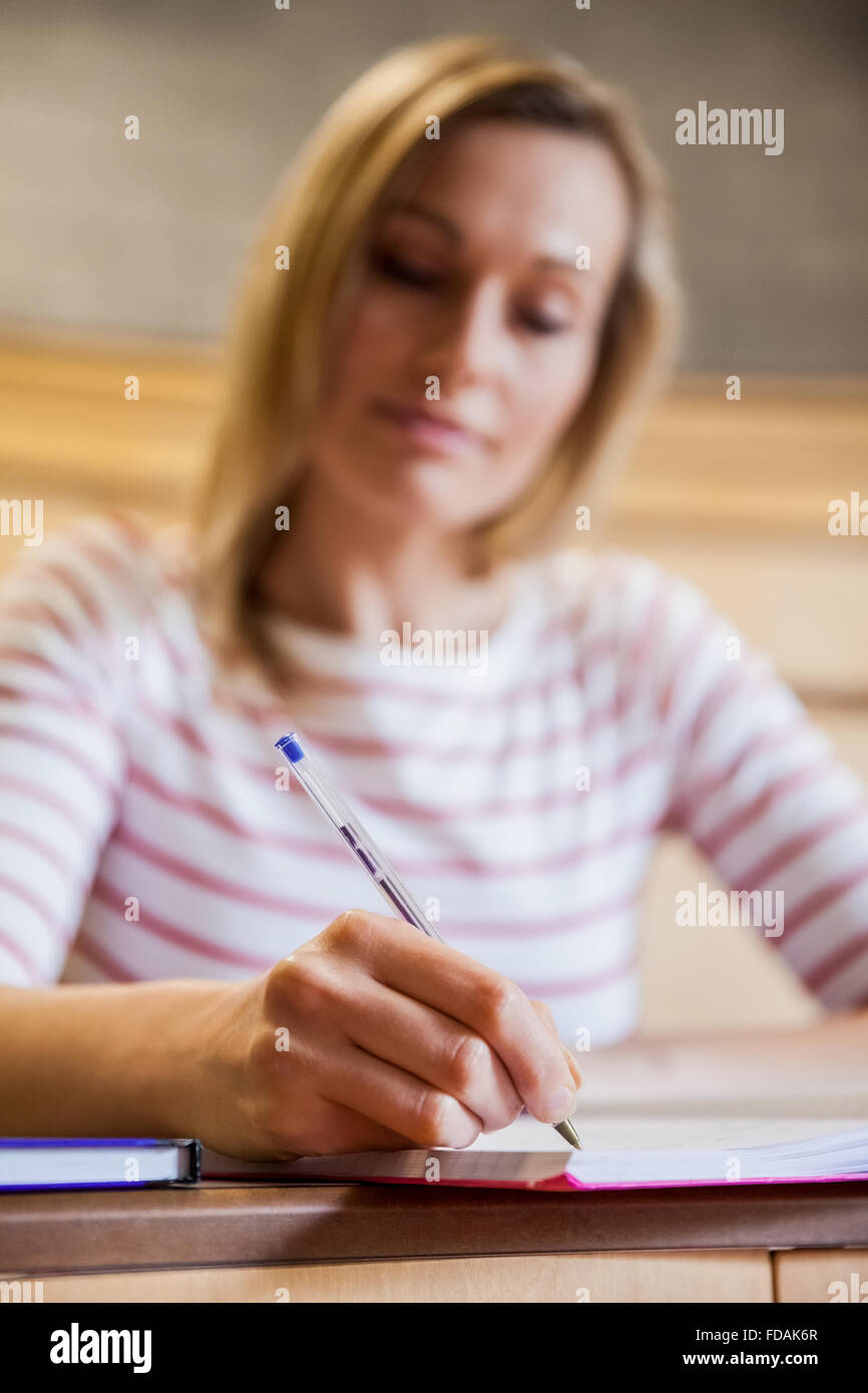 Female student taking notes in a class Stock Photo - Alamy