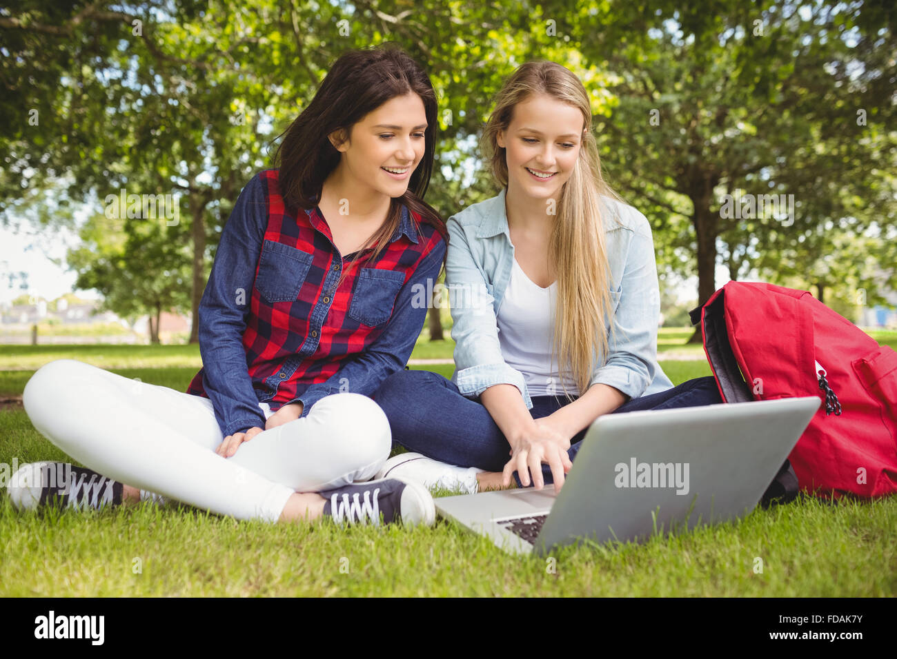 Smiling students using laptop Stock Photo - Alamy