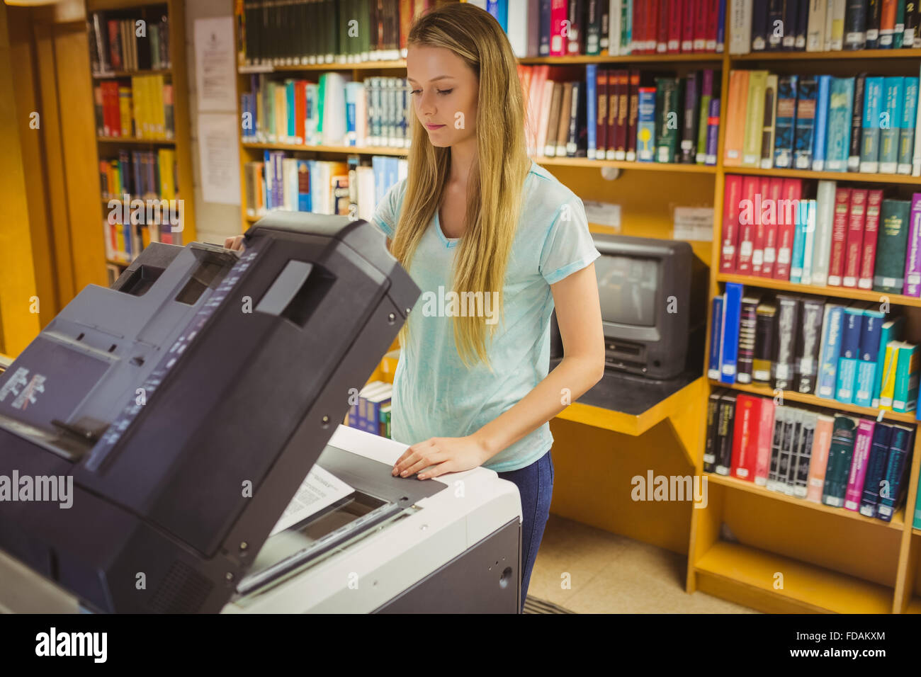 Smiling blonde student making a copy Stock Photo - Alamy