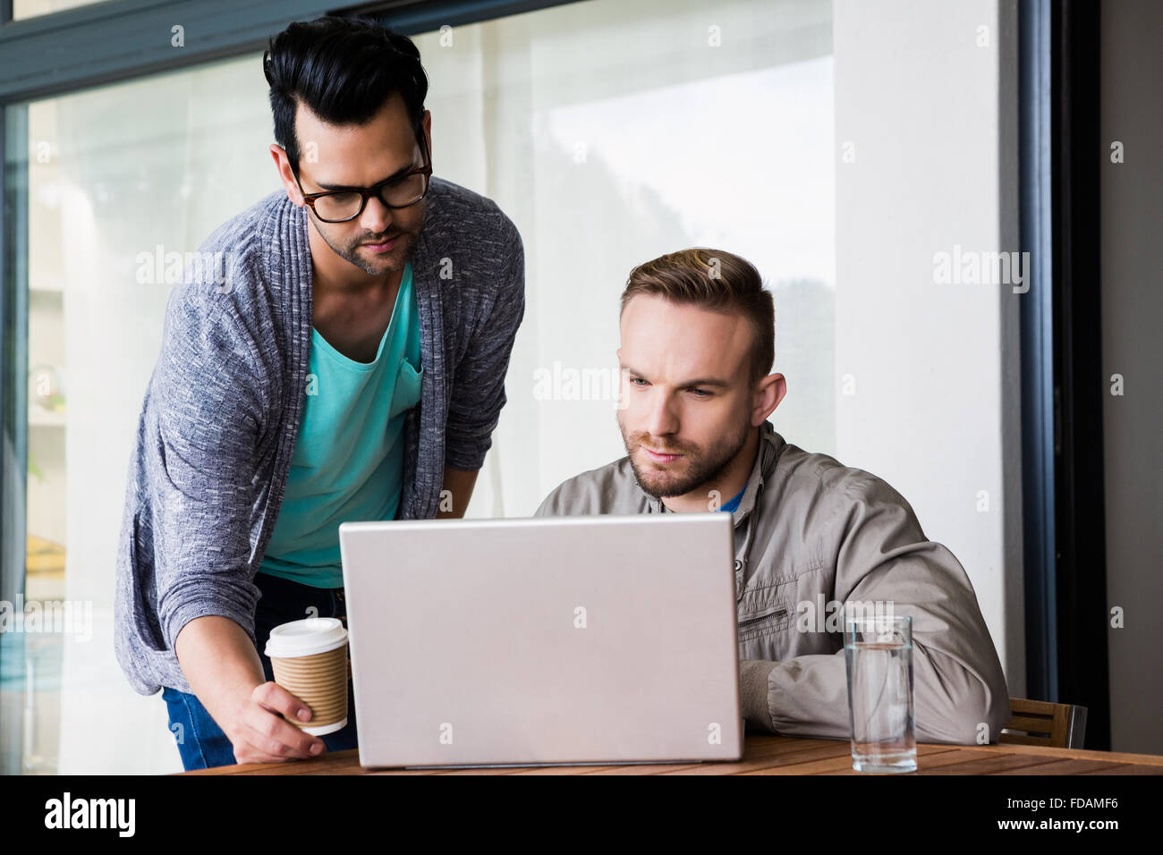 Focused gay couple using laptop Stock Photo - Alamy