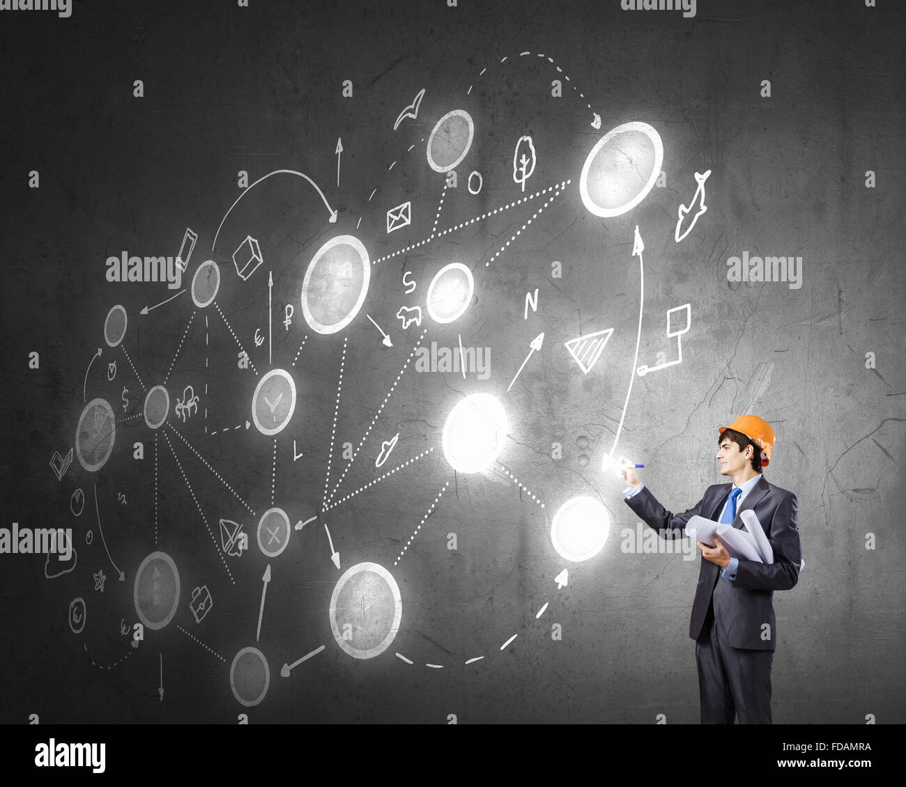 Young man engineer in helmet drawing connection lines Stock Photo - Alamy