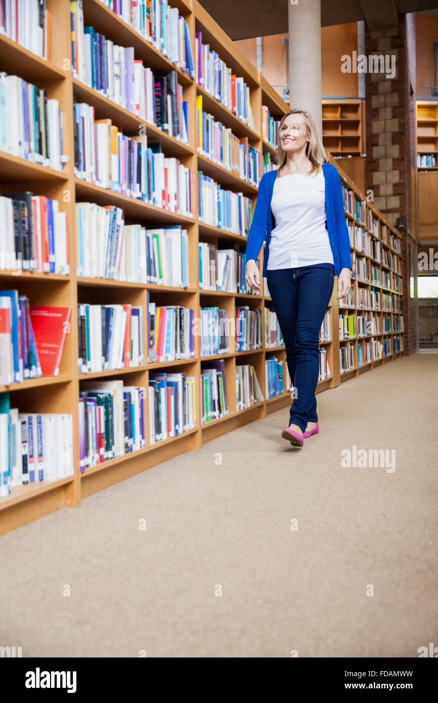 Female student walking in the library Stock Photo - Alamy