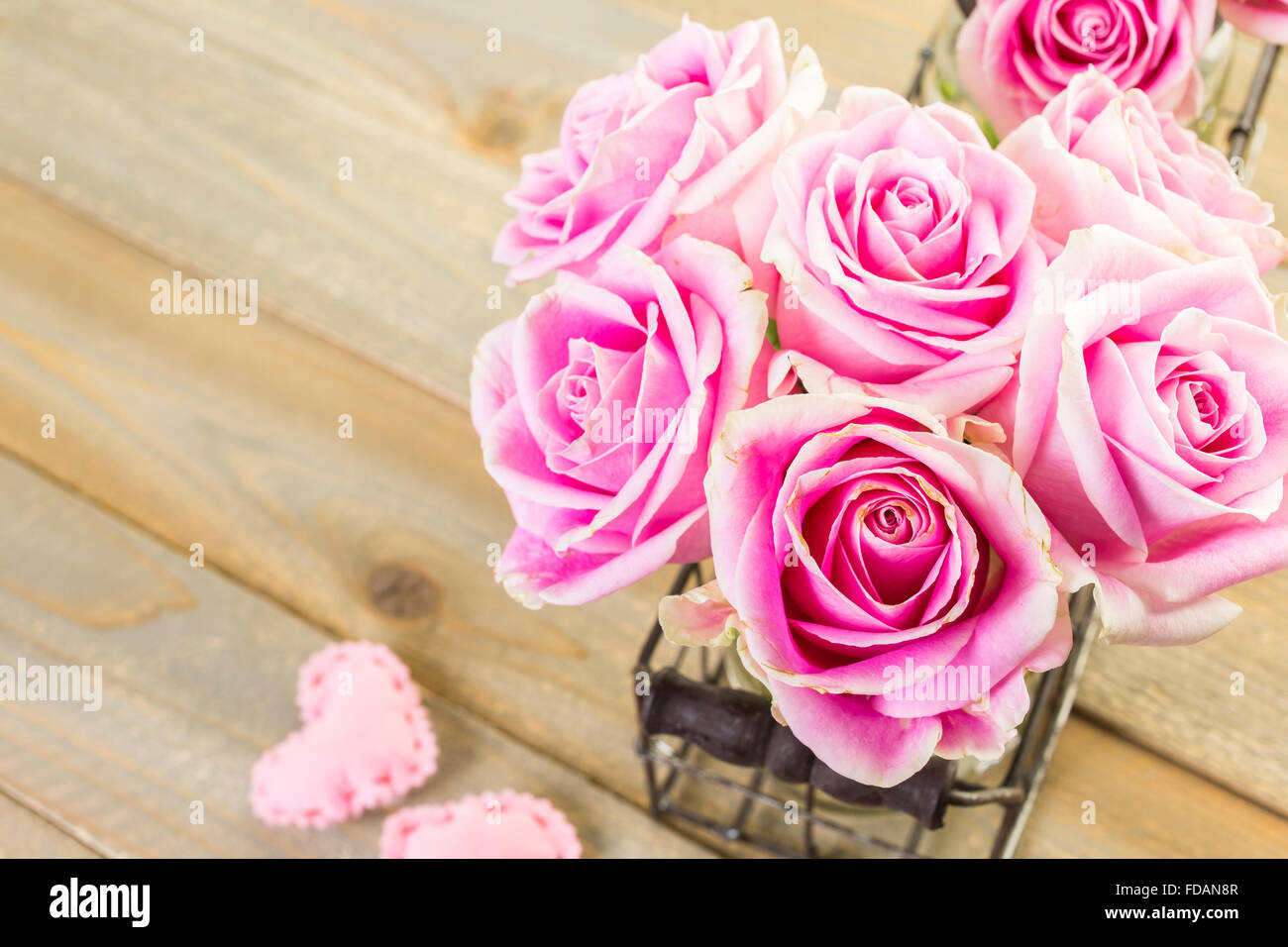 Pink roses in jars on rustic wood table Stock Photo - Alamy
