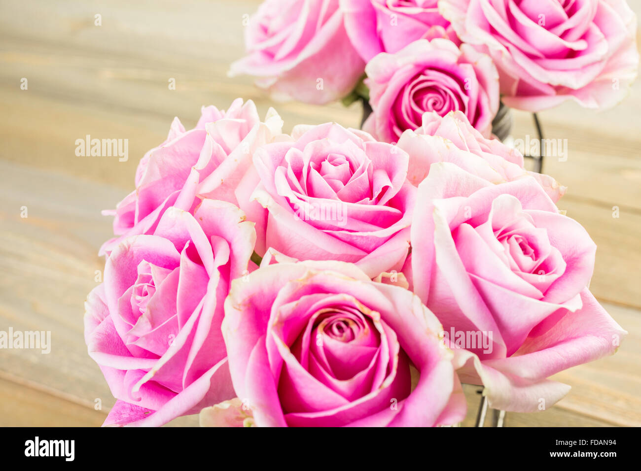 Pink roses in jars on rustic wood table Stock Photo - Alamy