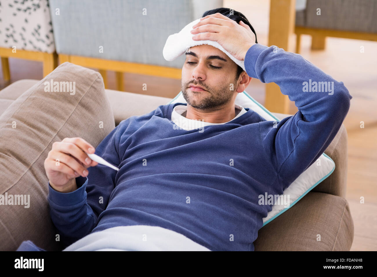 Sick man checking his temperature Stock Photo - Alamy