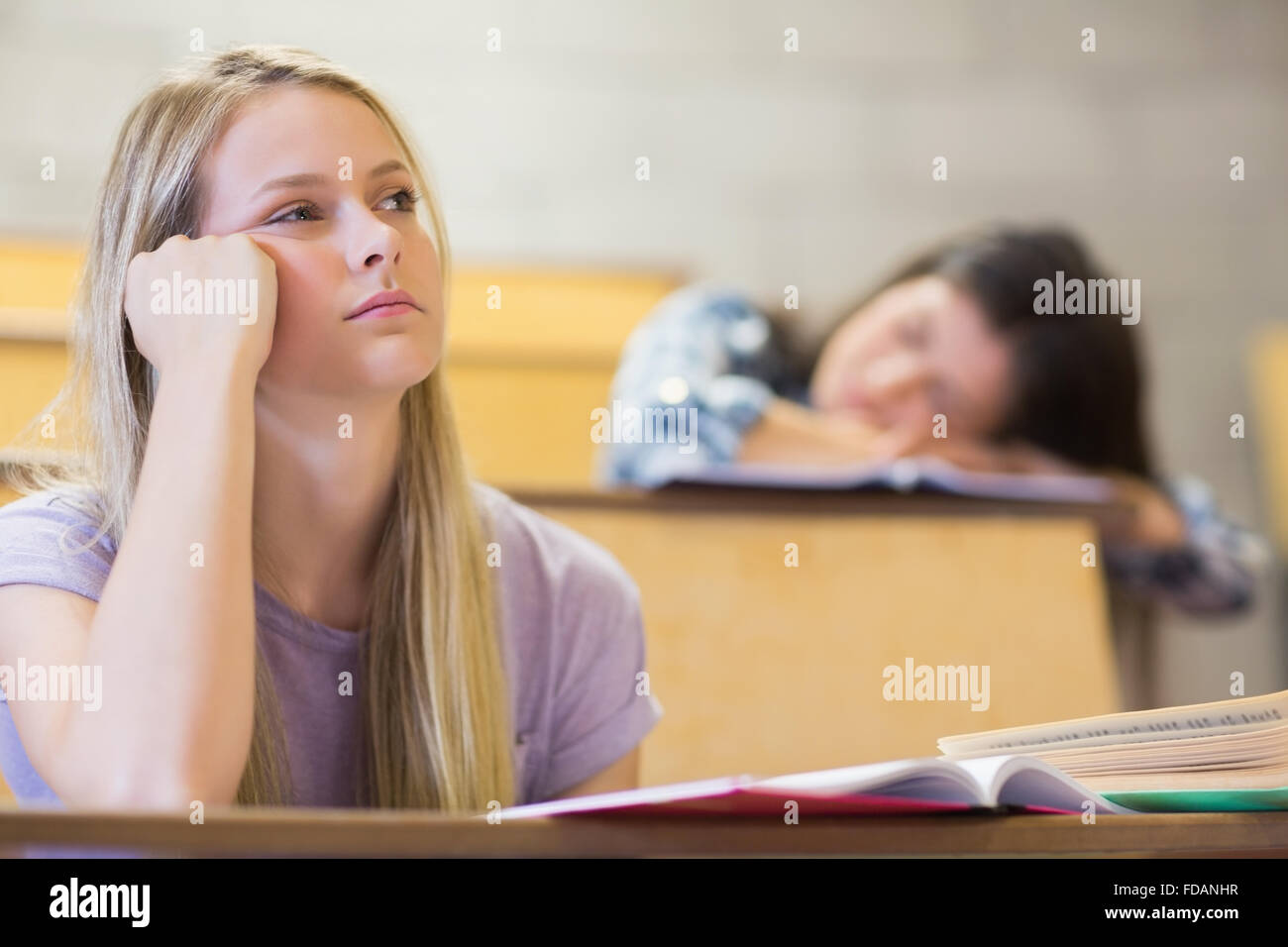 Bored student listening while classmate sleeping Stock Photo - Alamy