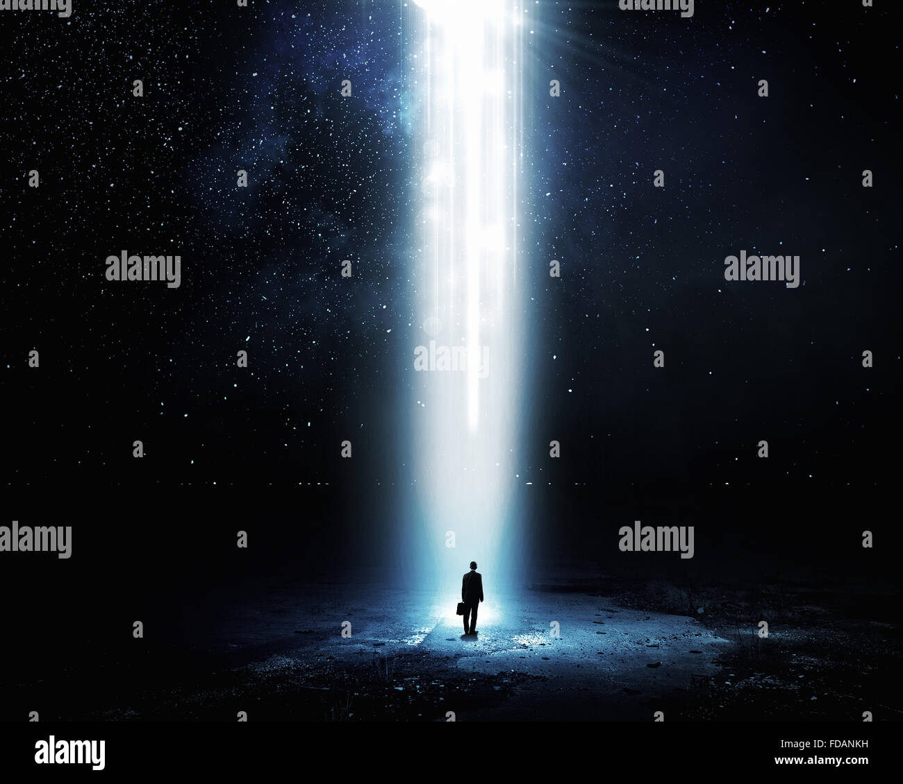 Rear view of businessman standing in light going from above Stock Photo ...
