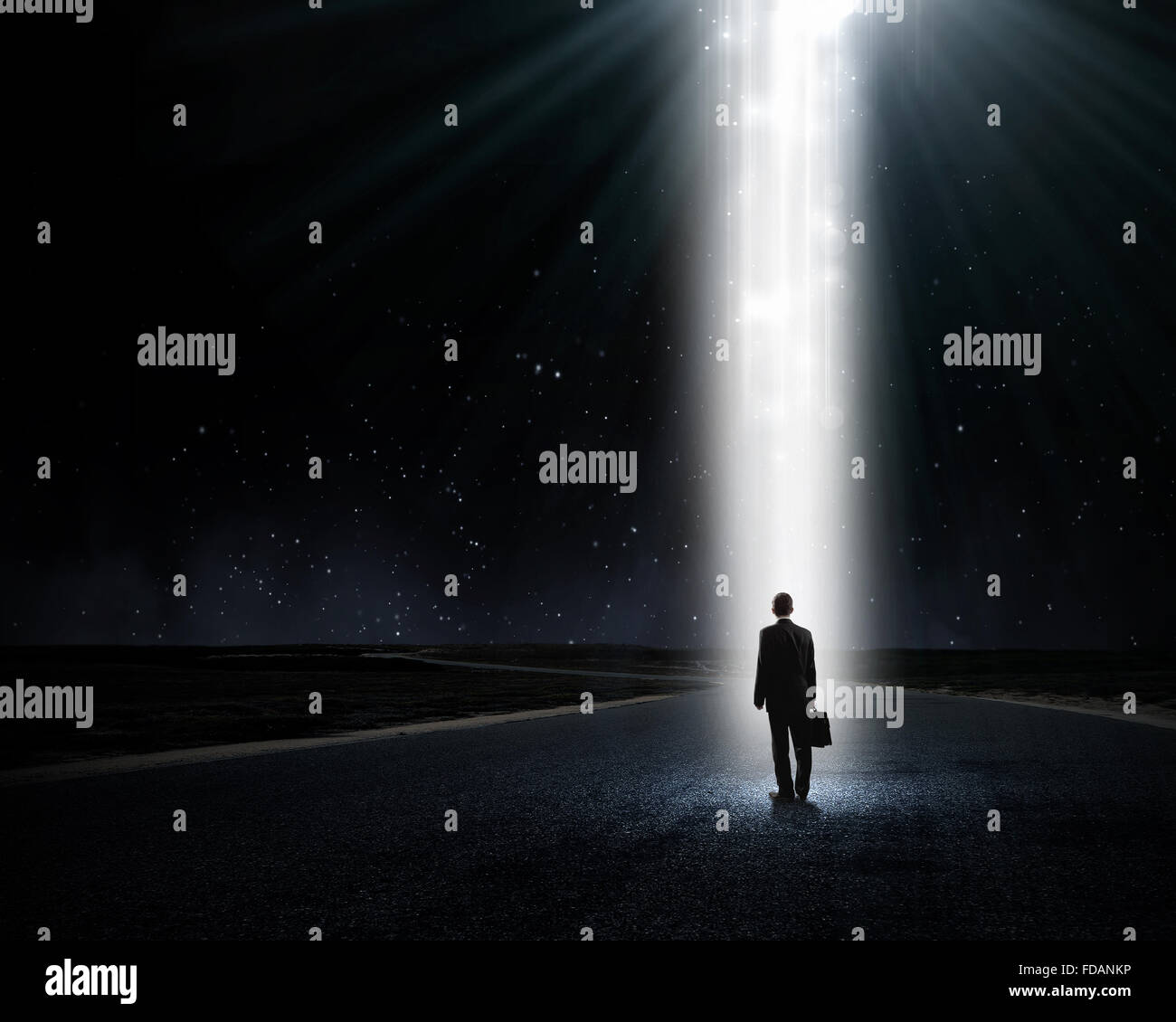 Rear view of businessman standing in light going from above Stock Photo ...