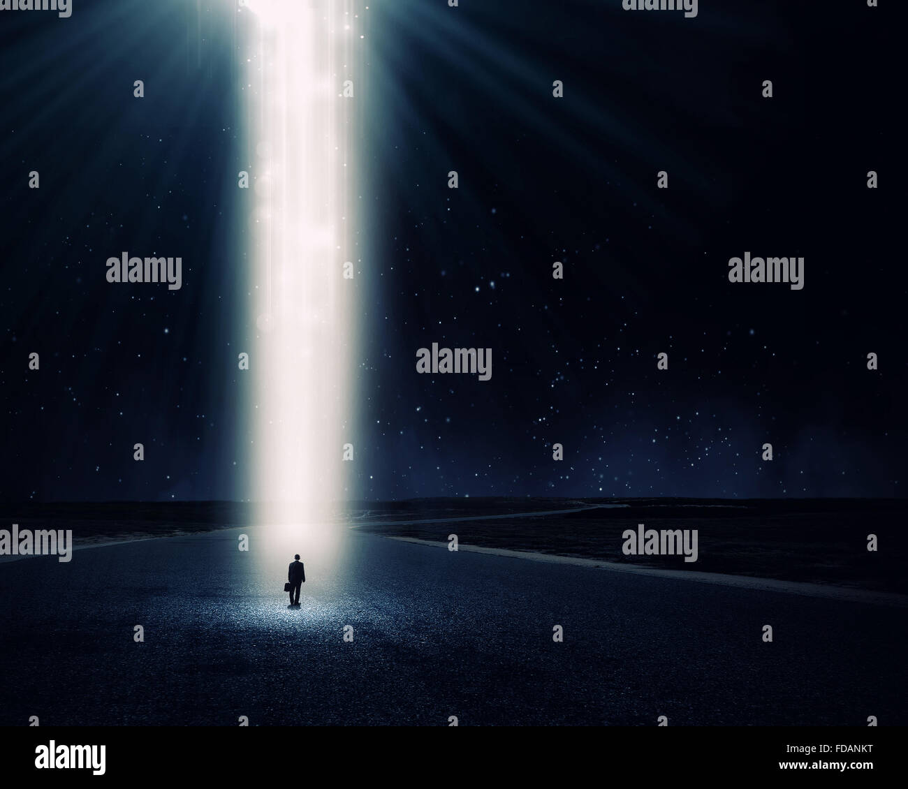 Rear view of businessman standing in light going from above Stock Photo ...