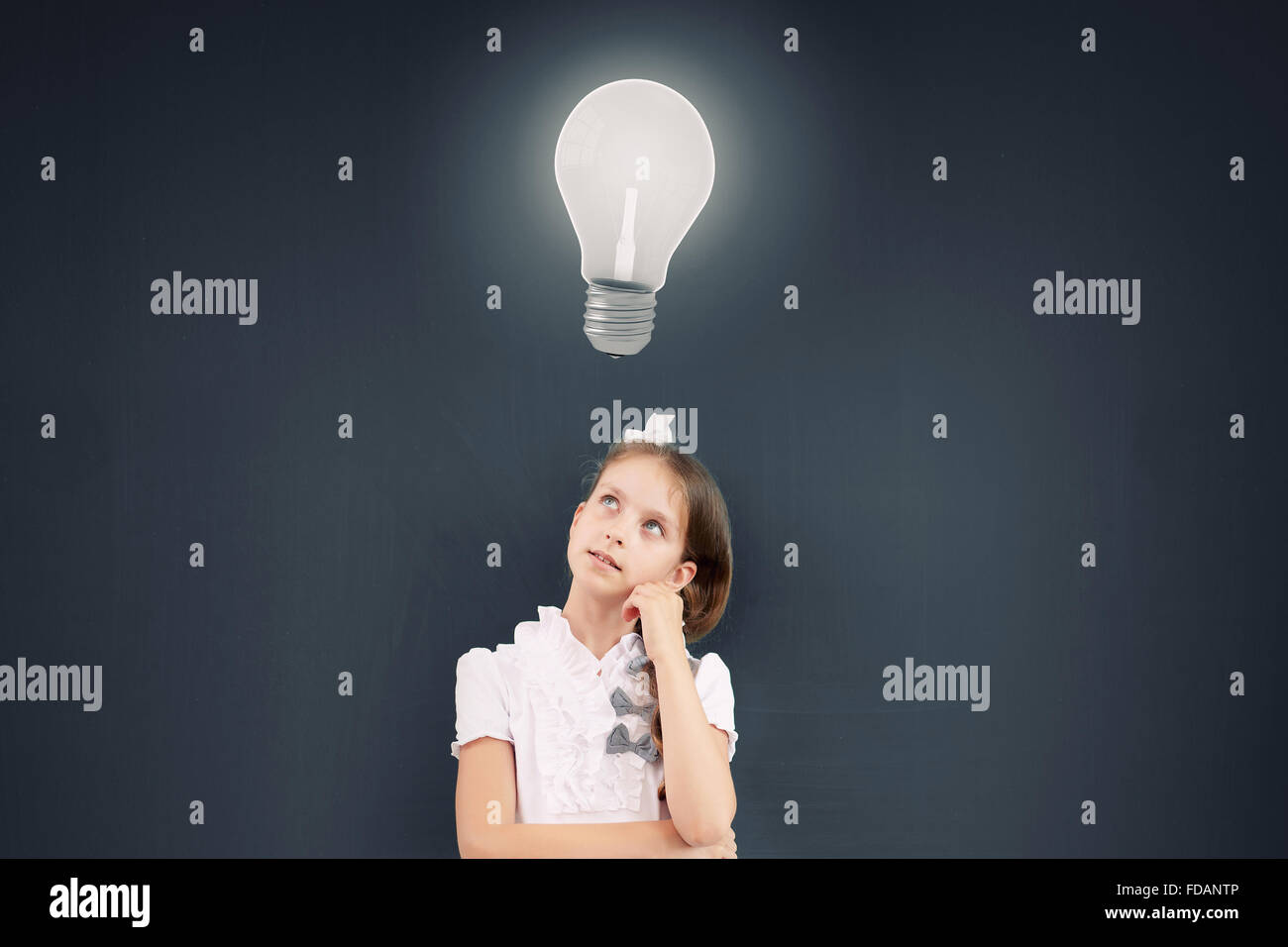 Cute thoughtful school girl and light bulb above her head Stock Photo ...