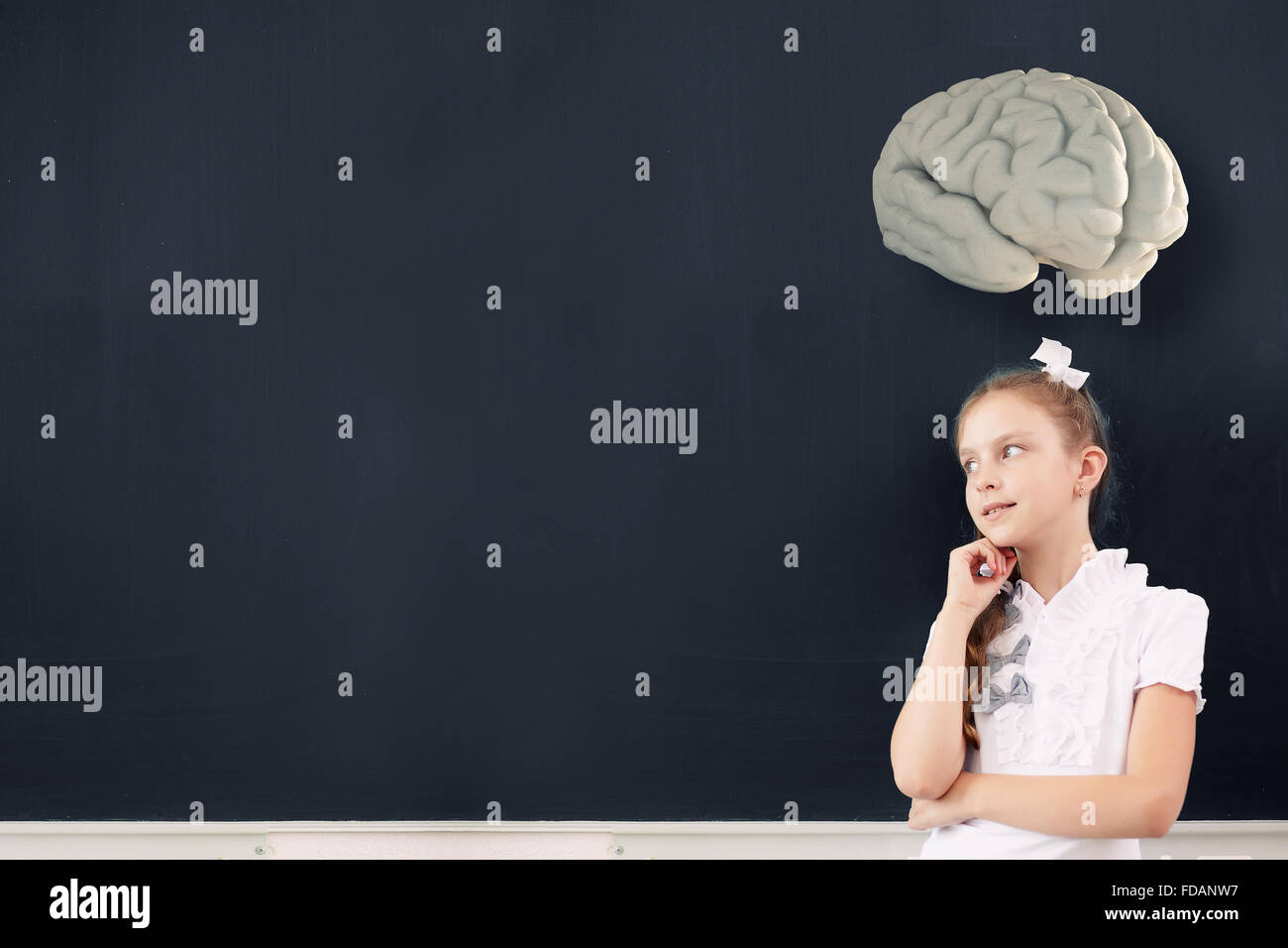 Cute thoughtful school girl and brain above her head Stock Photo - Alamy