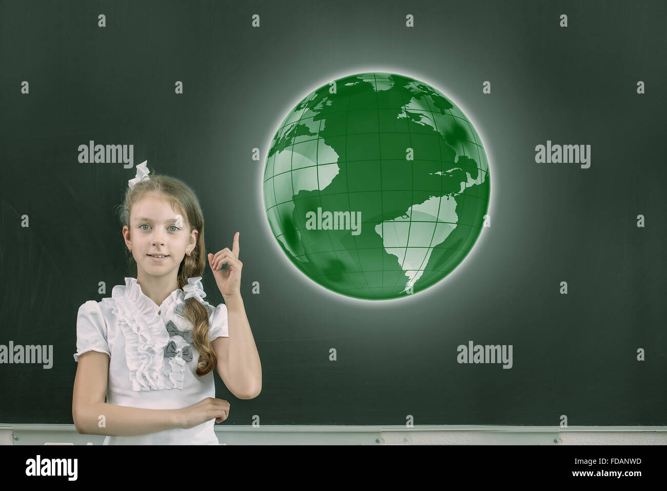 Cute school girl pointing at globe above her head Stock Photo - Alamy