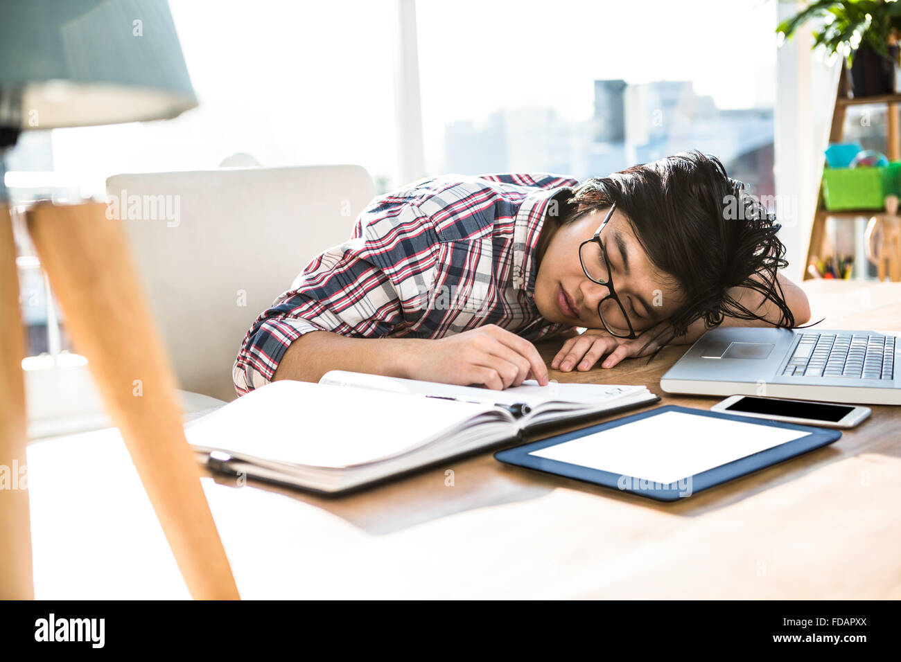 Hipster businessman falling asleep on desk Stock Photo - Alamy