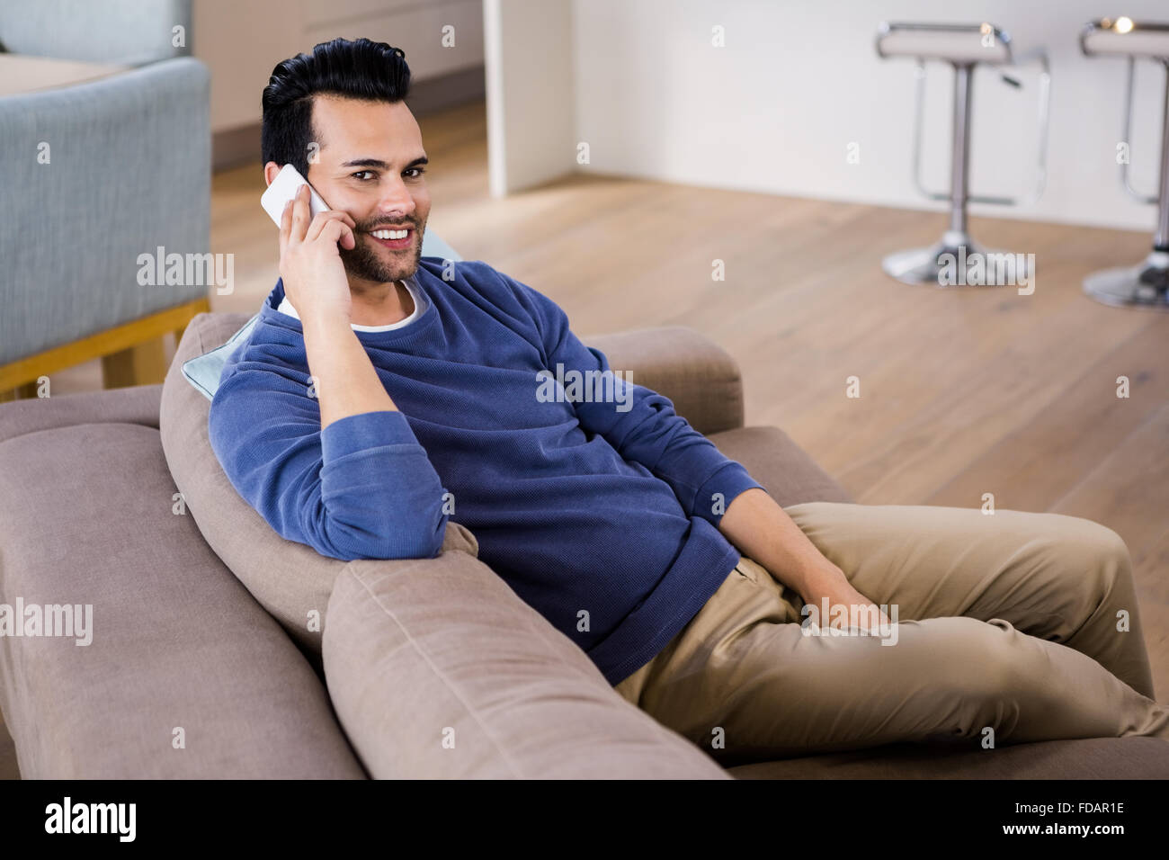 Handsome man calling on the couch Stock Photo - Alamy