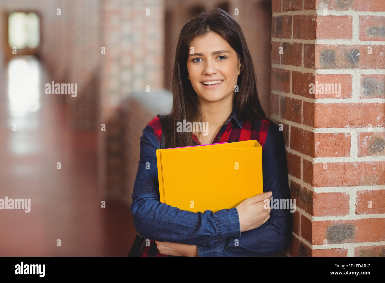 Smiling student with binder posing Stock Photo - Alamy