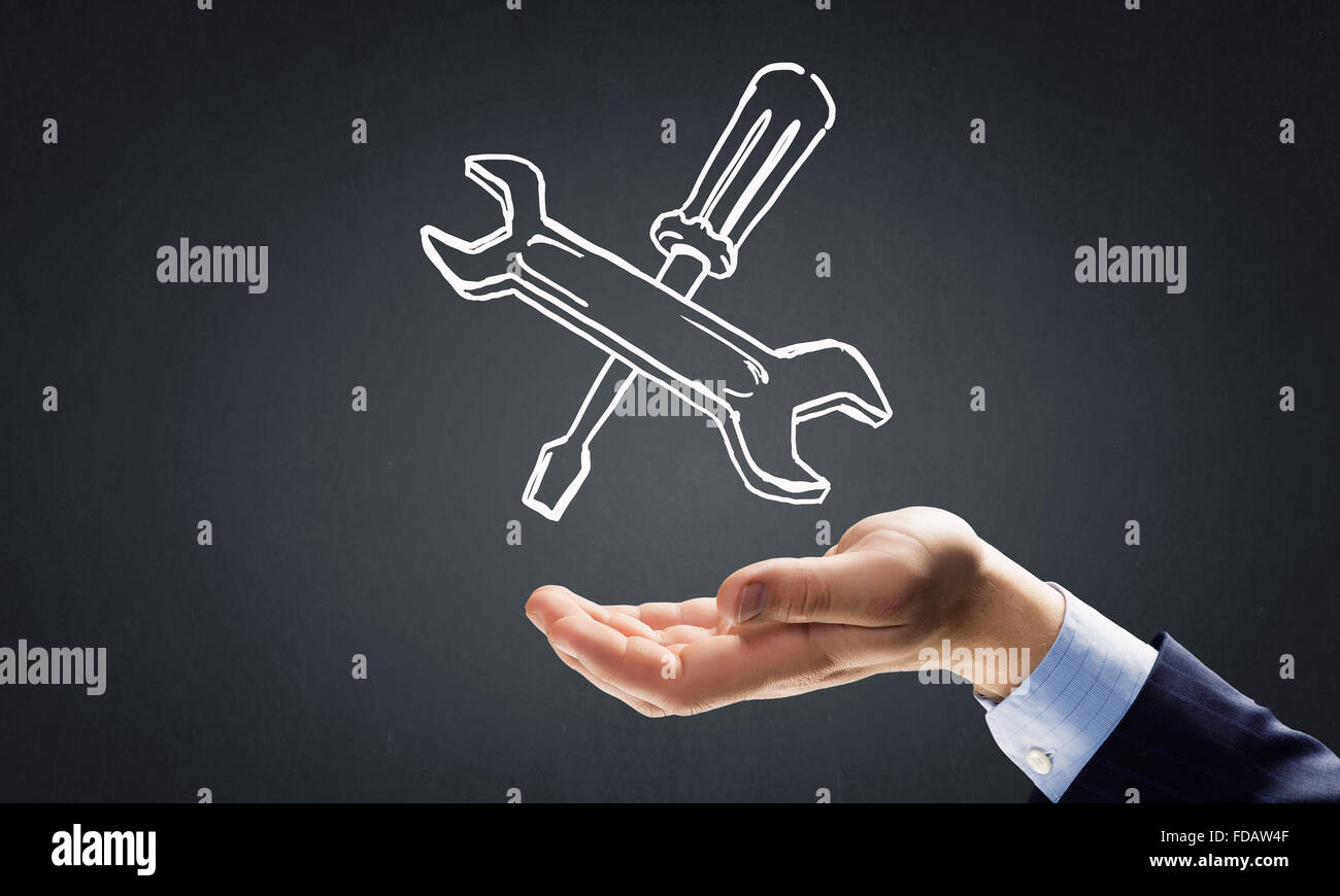 Businessman's hand holding tools over gray background Stock Photo - Alamy