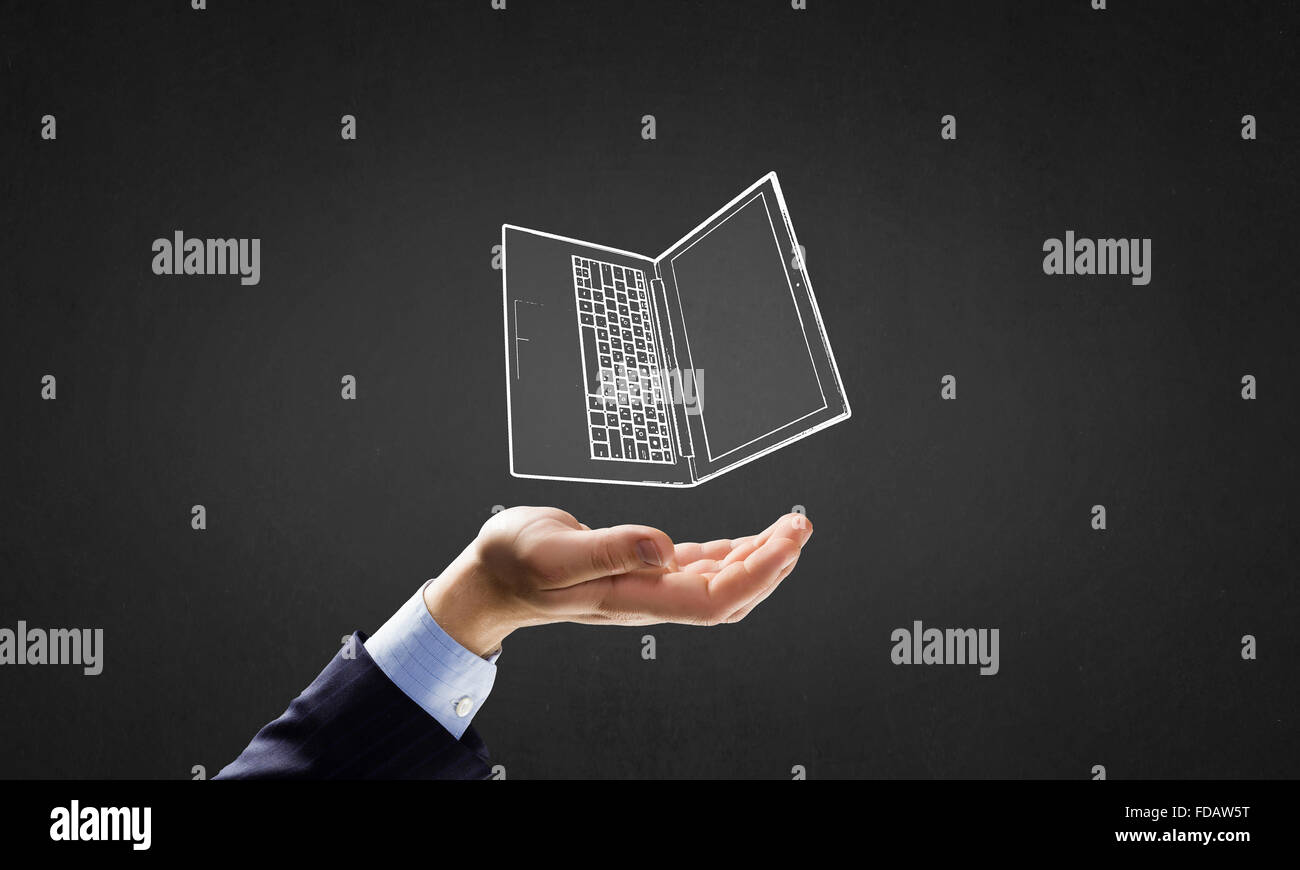 Human hand holding in palm laptop symbol Stock Photo - Alamy