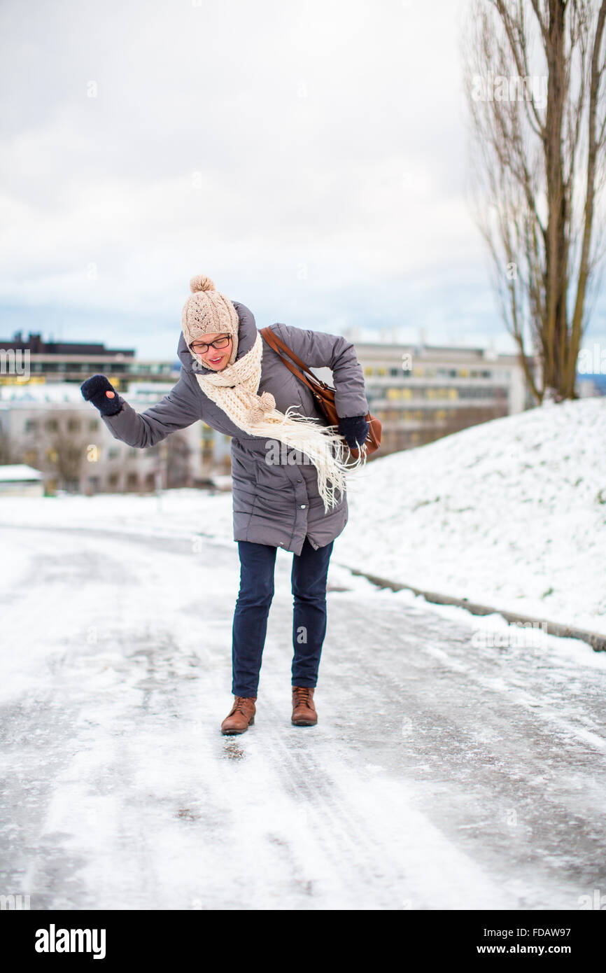 Pretty, young woman having troubles walking on an icy, slippery ...