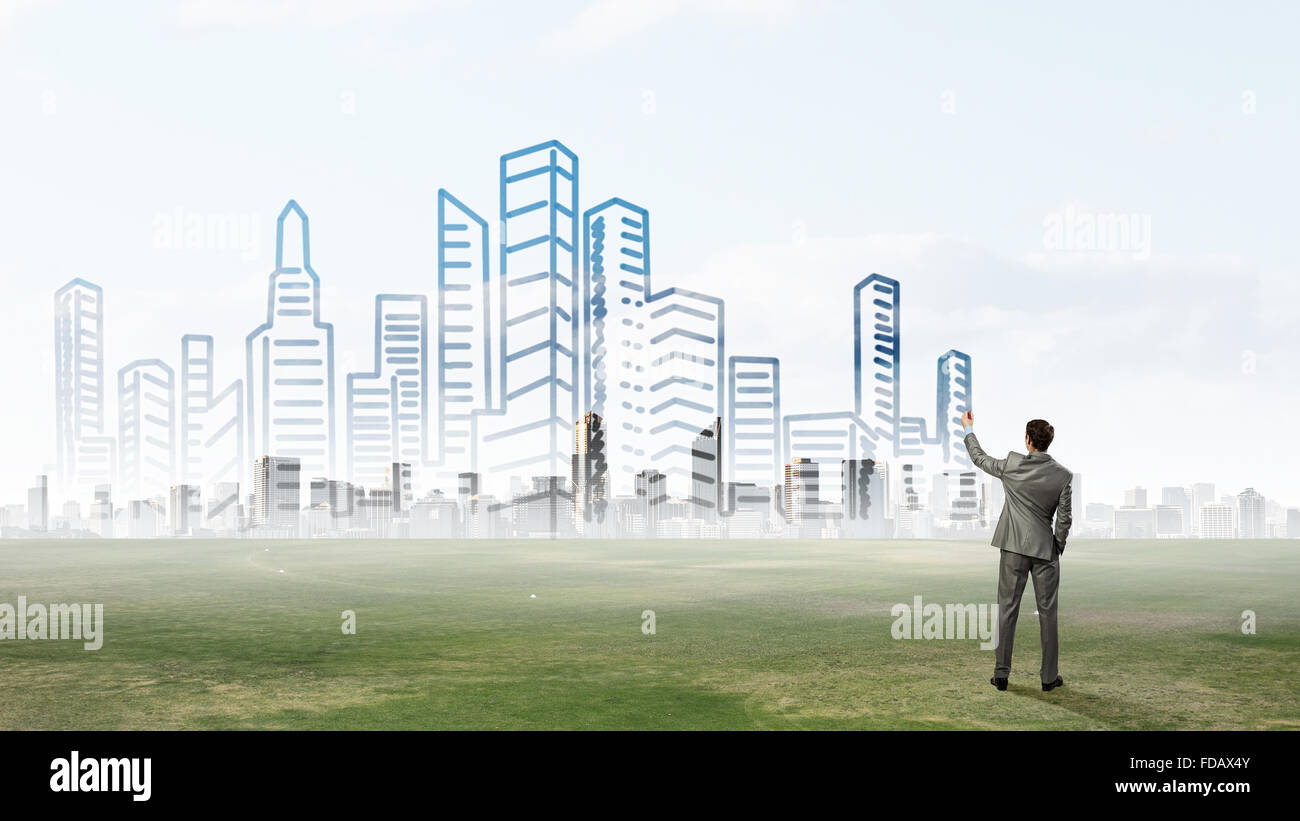 Back view of businessman drawing sketches of construction project on ...