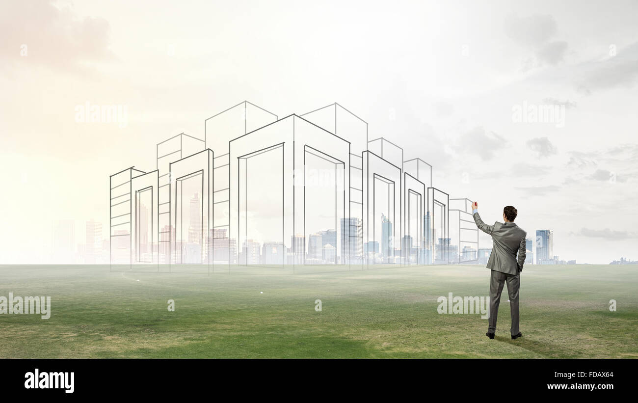 Back view of businessman drawing sketches of construction project on ...