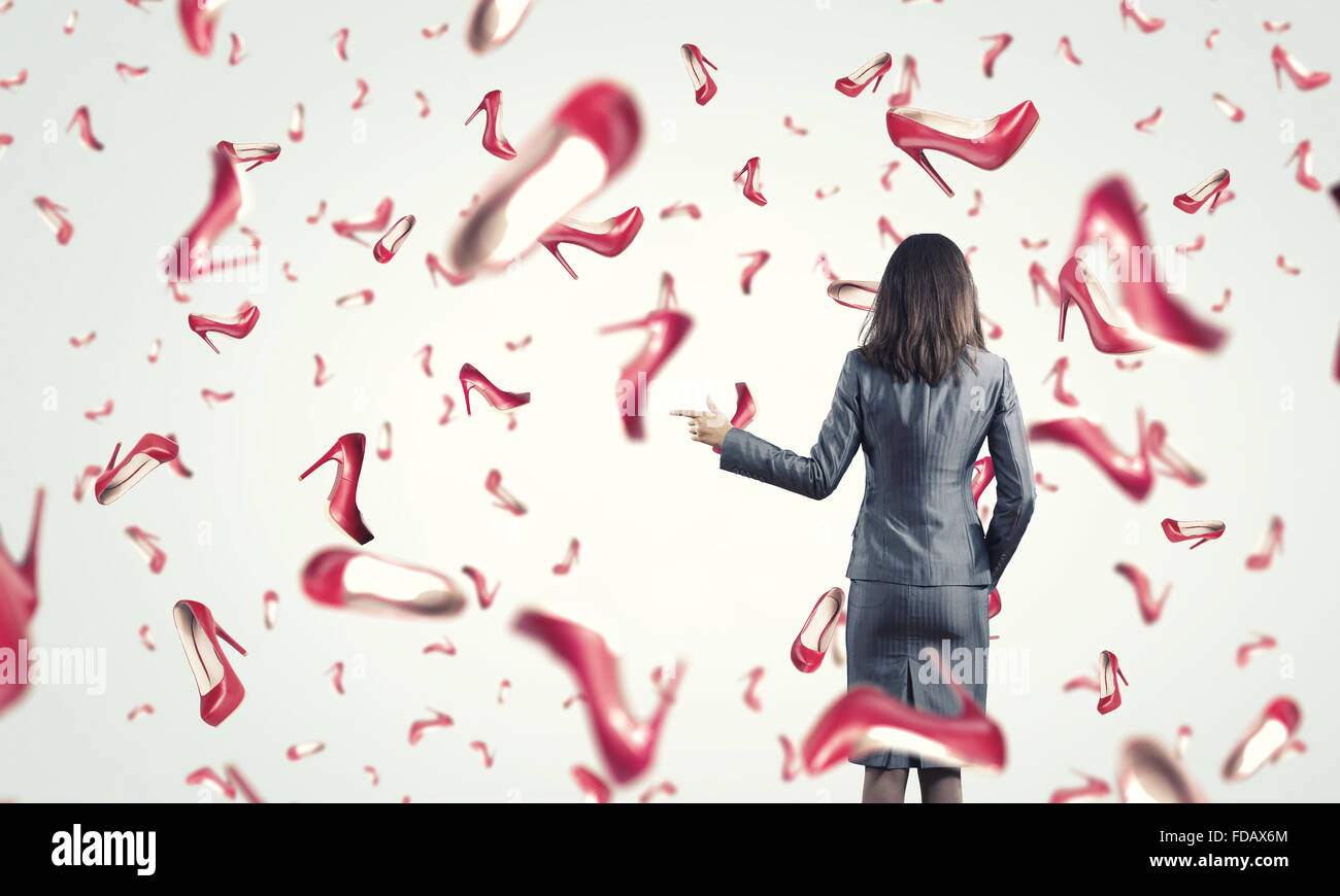 Rear woman in suit and many falling shoes Stock Photo - Alamy