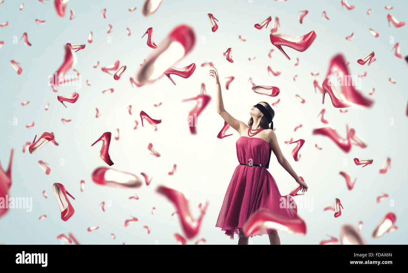 Young woman in dress and many falling shoes Stock Photo - Alamy