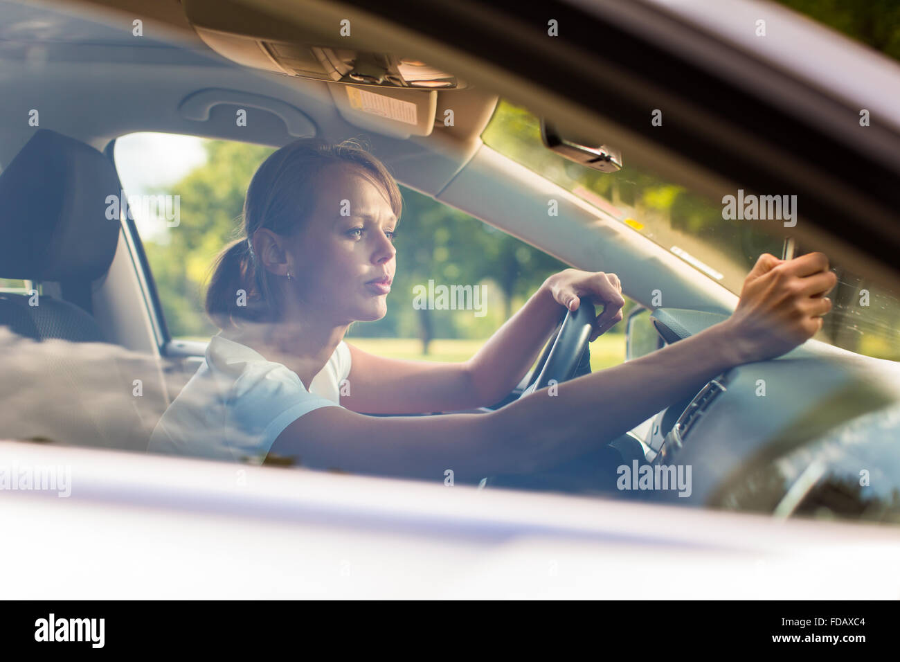 Young woman driving her car, on her way home from work - doing the ...