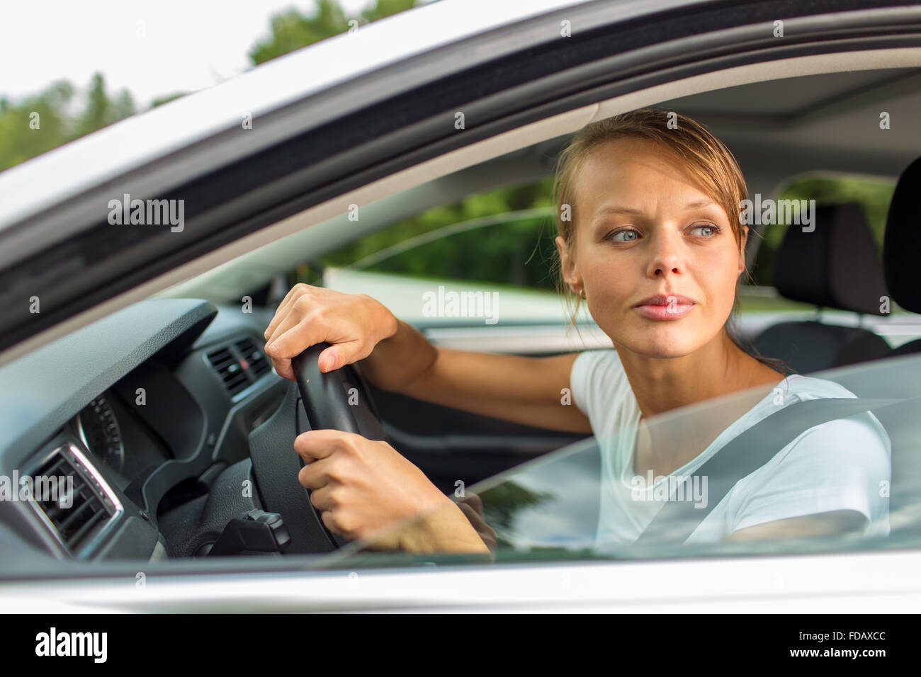 Young woman driving her car, on her way home from work - doing the ...