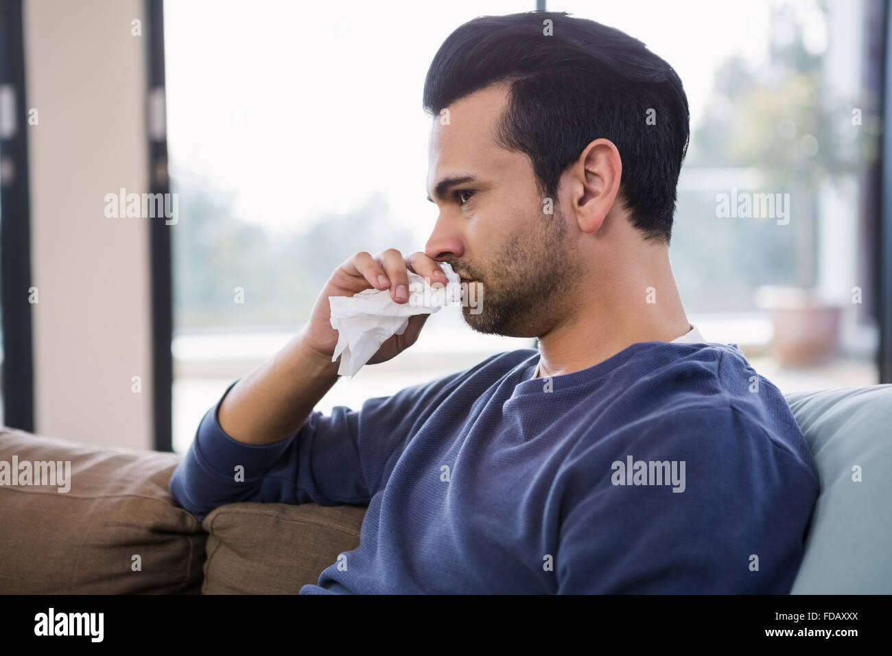 Handsome man sneezing Stock Photo - Alamy
