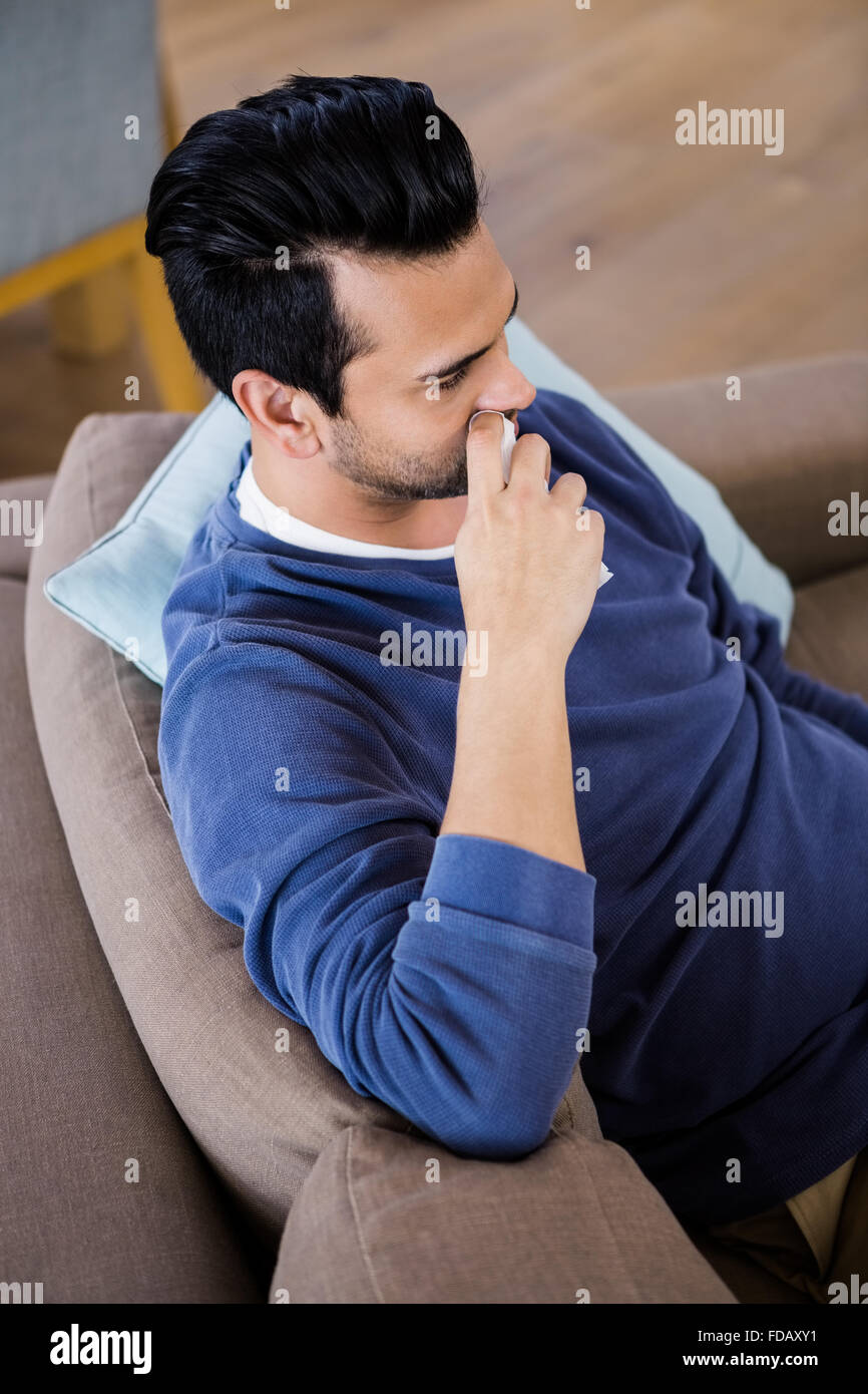 Handsome man sneezing Stock Photo - Alamy