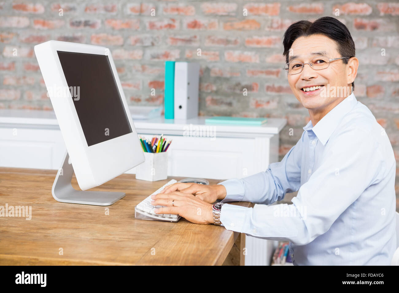 Smiling man using computer Stock Photo - Alamy