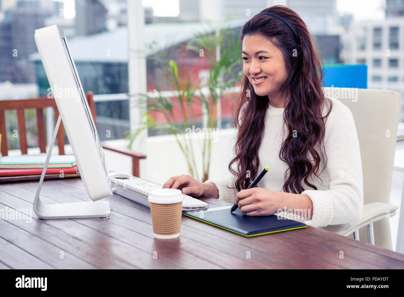 Smiling Asian woman using digital board and computer Stock Photo - Alamy