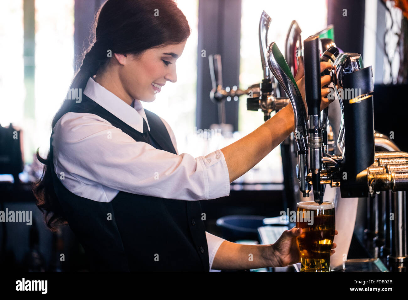 Barmaid serving a pint Stock Photo - Alamy