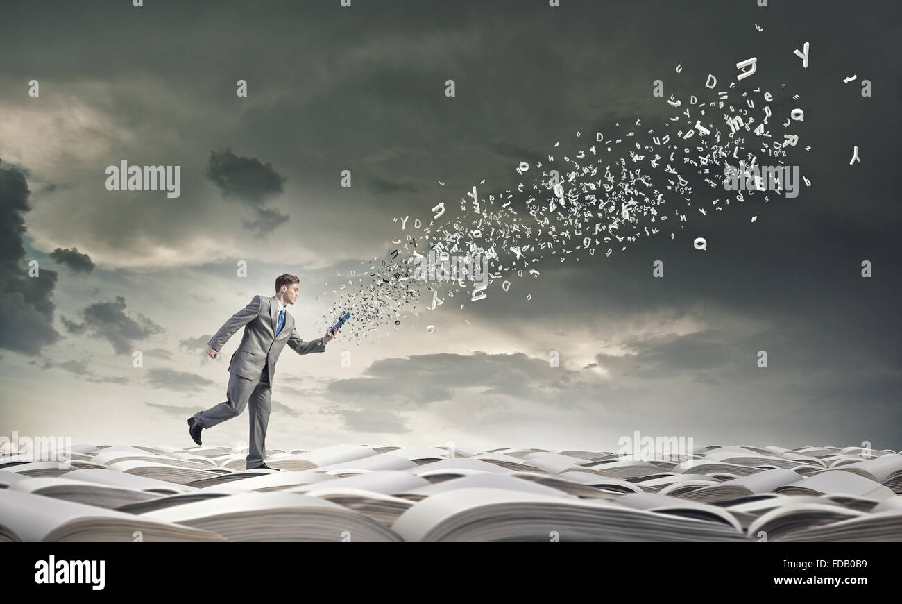 Young businessman running with book in hand Stock Photo - Alamy