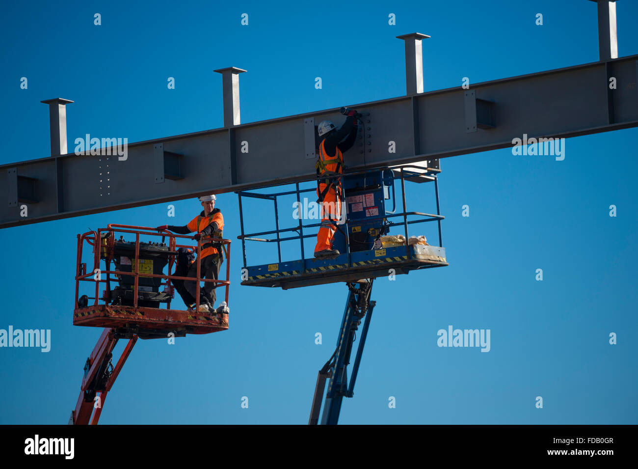 Men working at height from 'cherry picker' elevated platforms ...